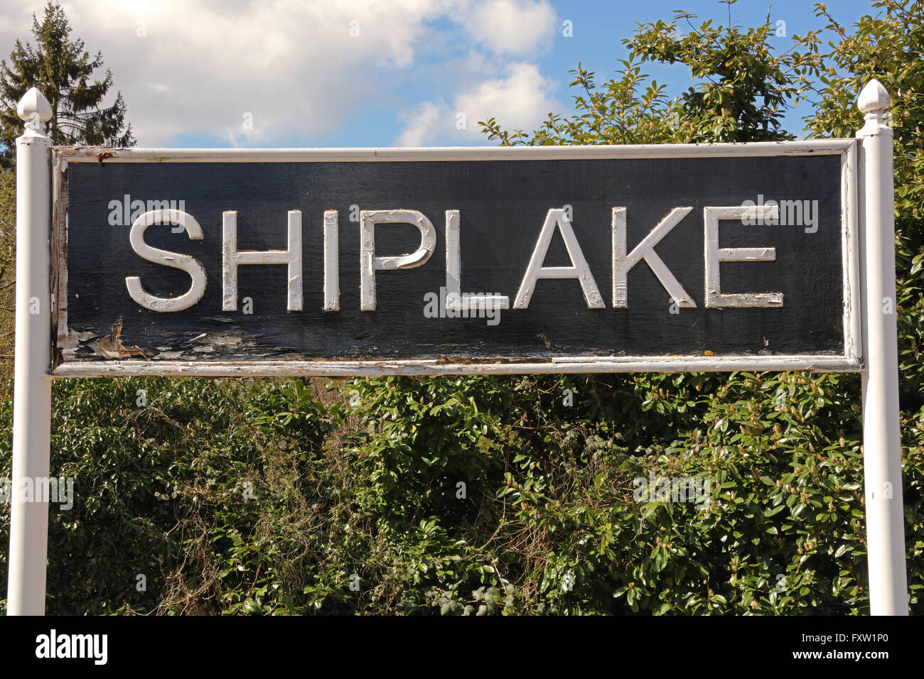 An old black and white flaking painted wooden platform sign mounted ...