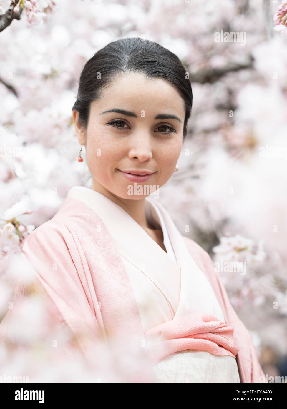 Portrait of young Japanese woman wearing kimono with cherry blossom in ...