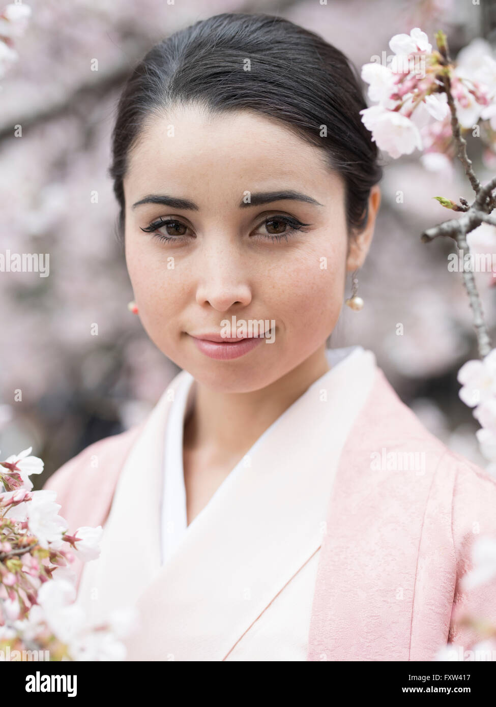 Portrait of young Japanese woman wearing kimono with cherry blossom in ...