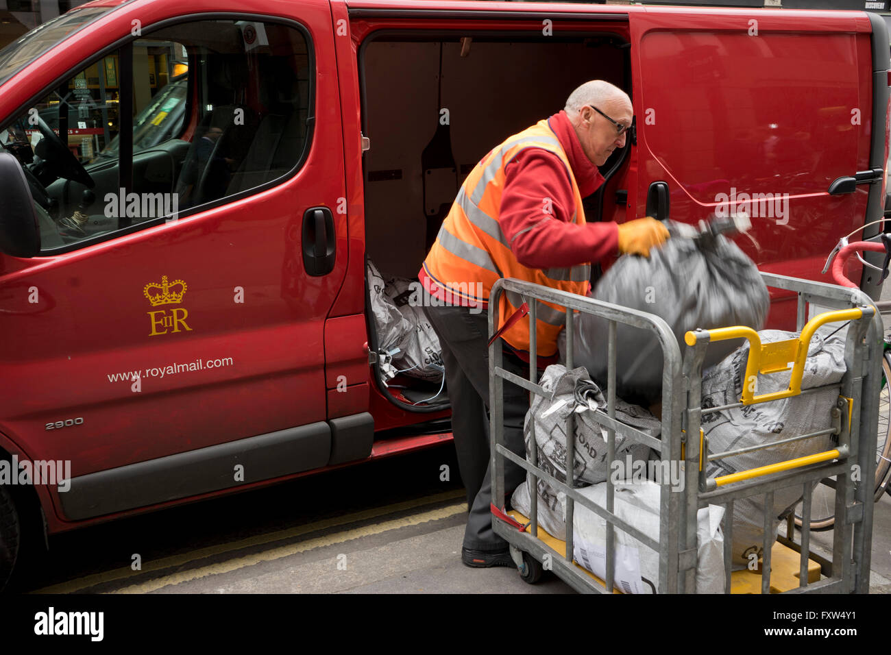 Post Office worker loading packages into van. London, England, UK Stock ...