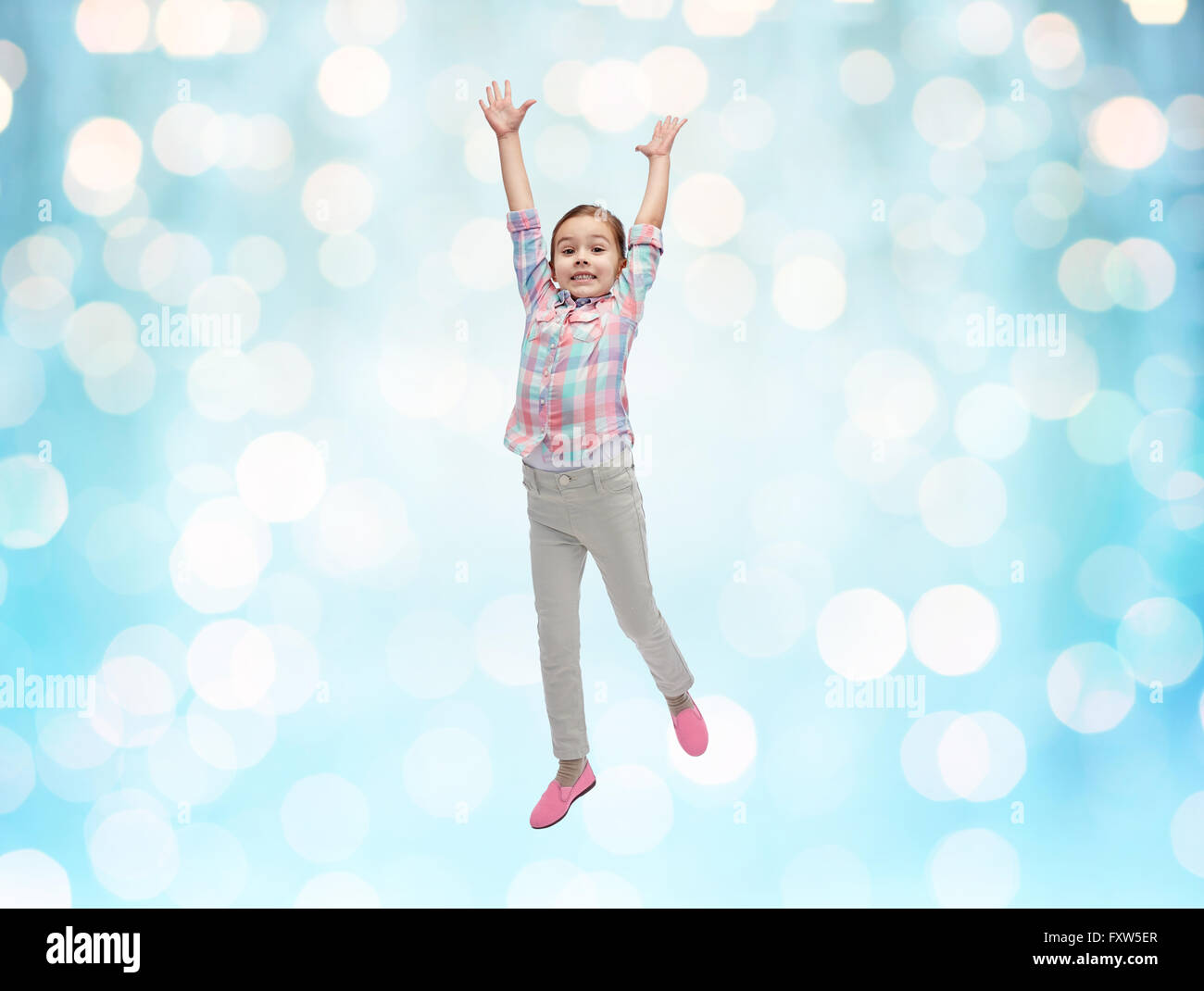 happy little girl jumping in air over blue lights Stock Photo - Alamy