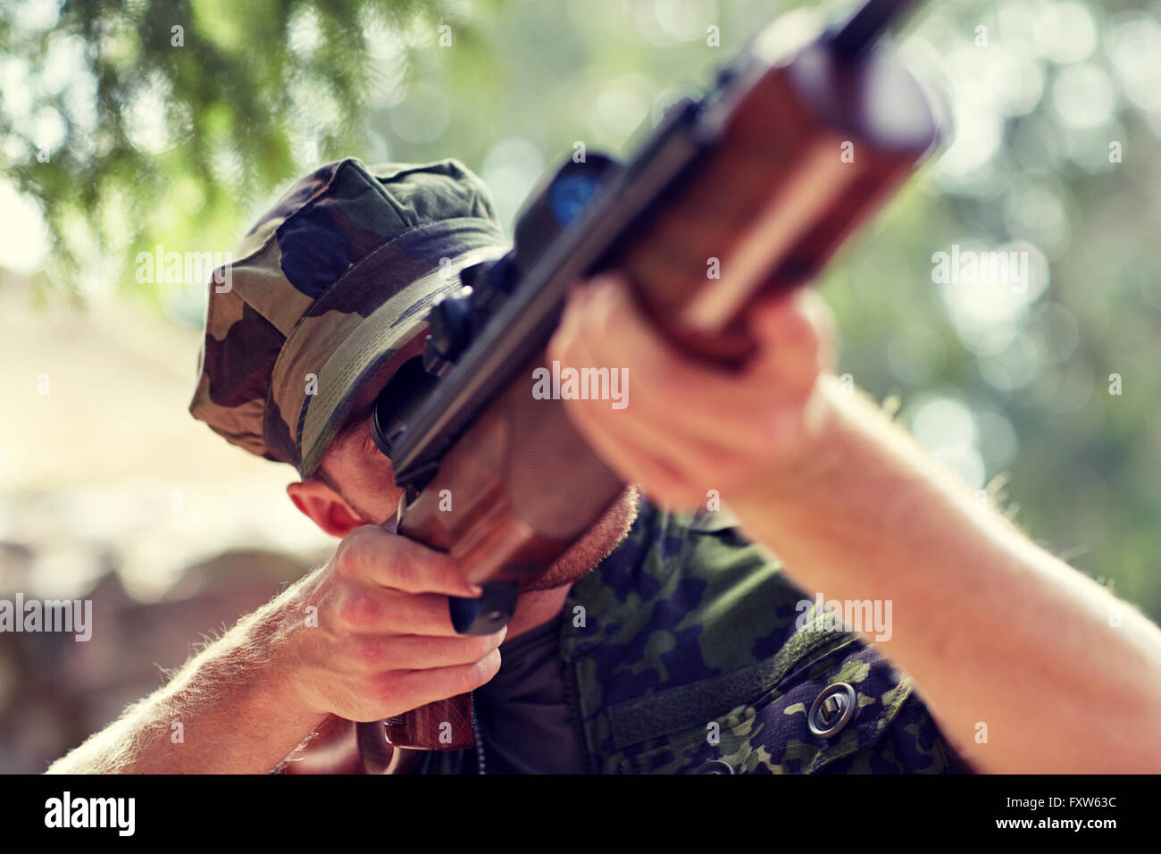 soldier or hunter shooting with gun in forest Stock Photo - Alamy