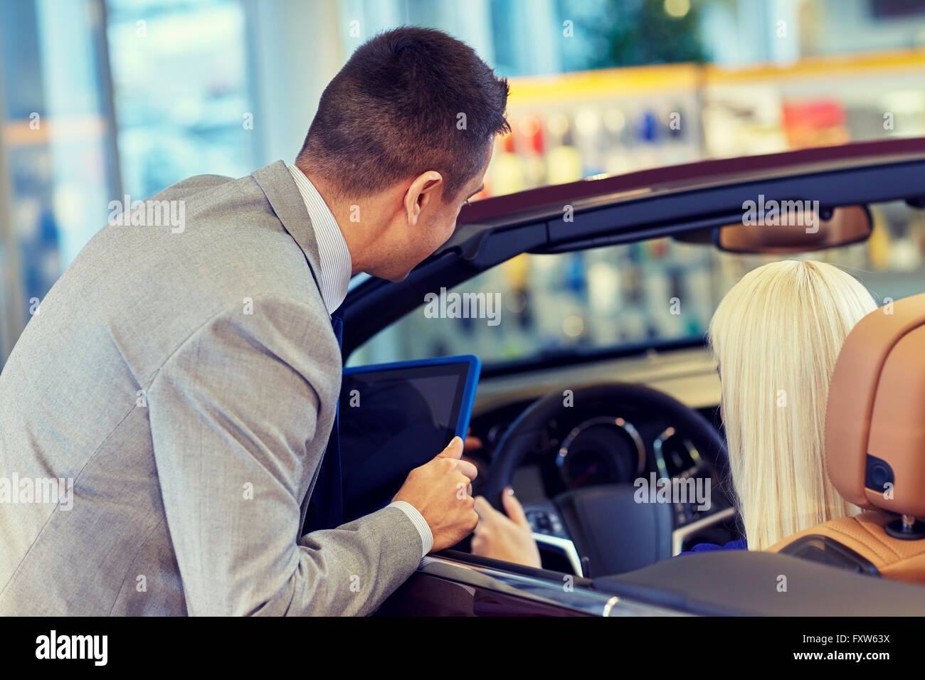 woman and car dealer with tablet pc in auto salon Stock Photo - Alamy