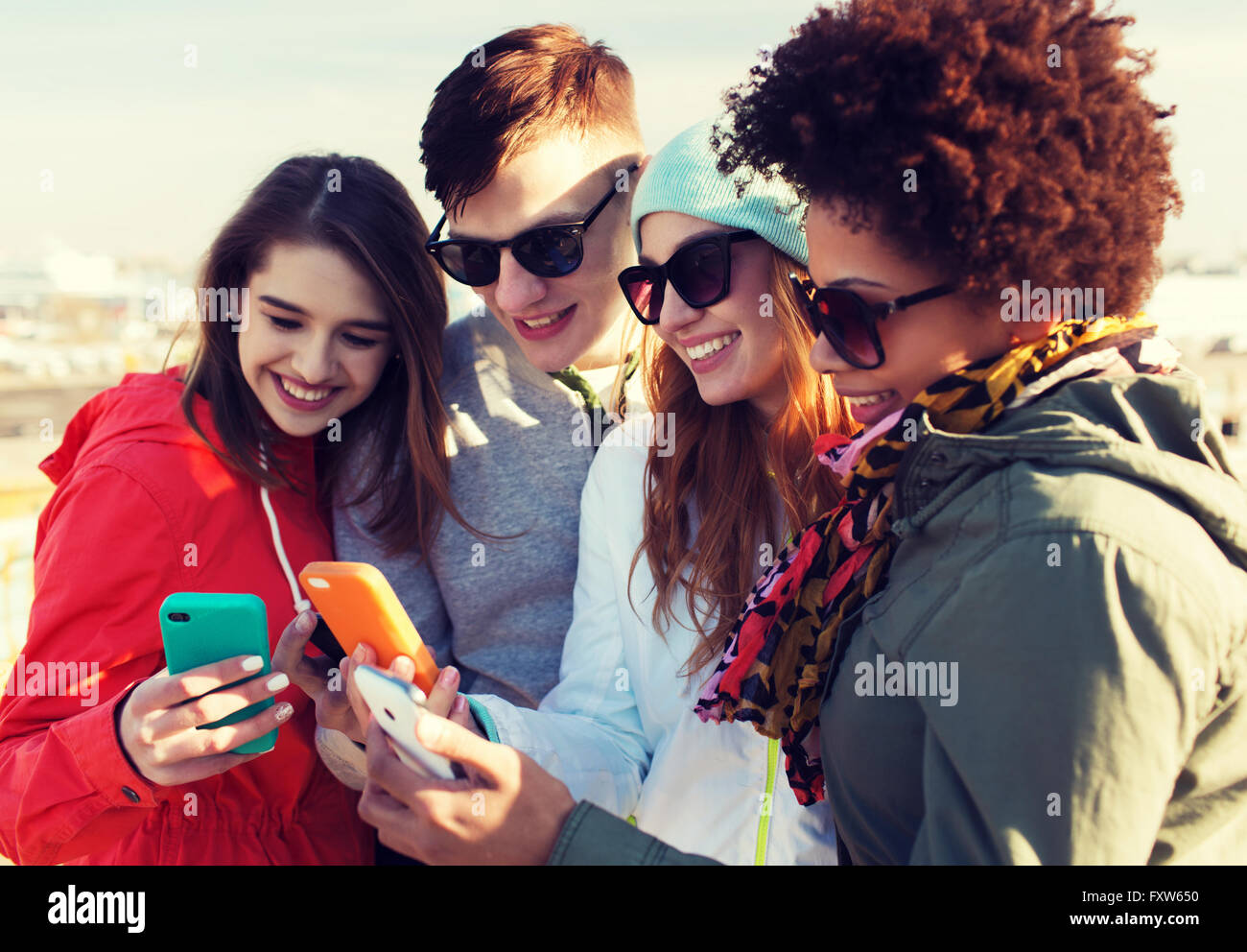 smiling friends with smartphones Stock Photo - Alamy