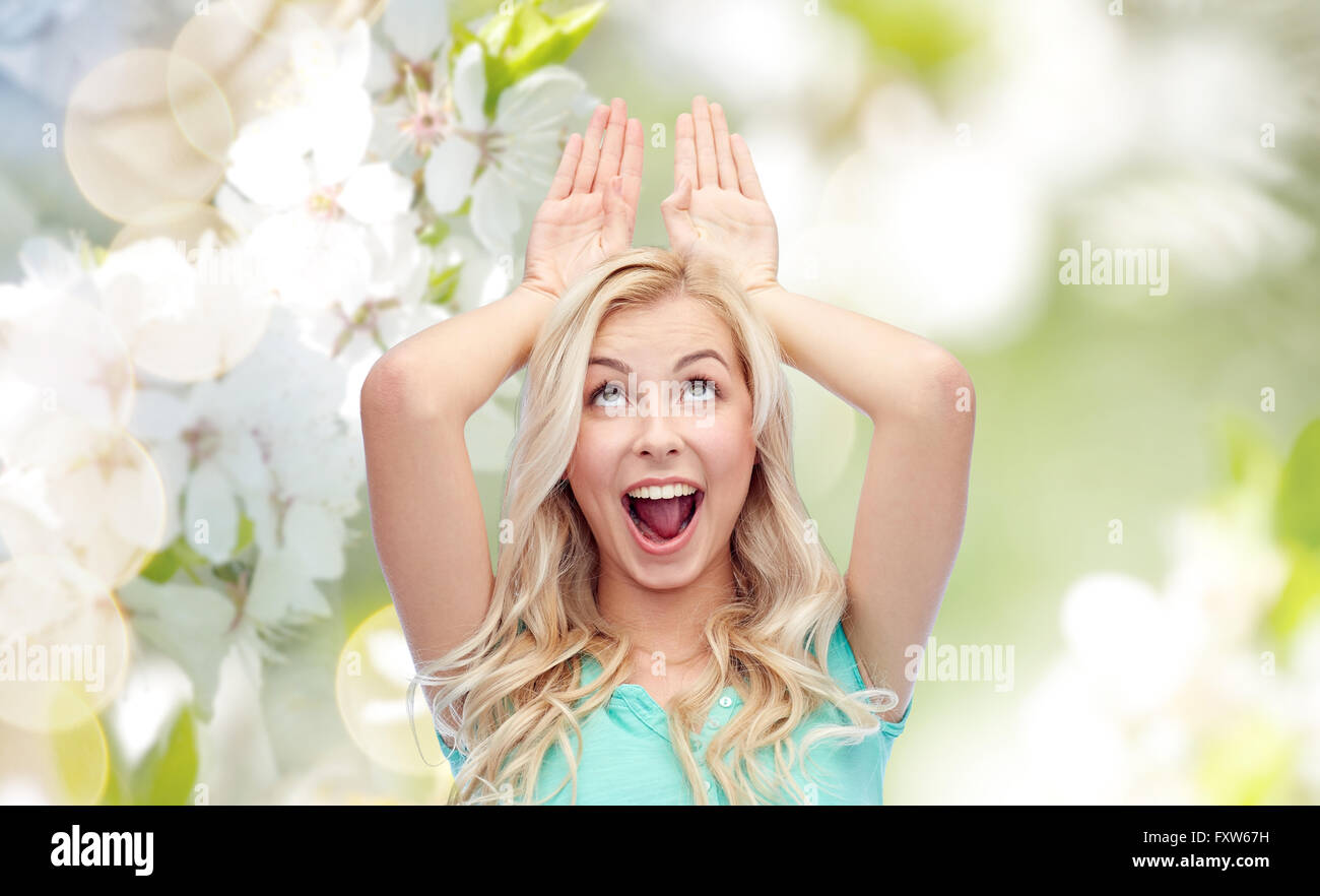 happy smiling young woman making bunny ears Stock Photo - Alamy