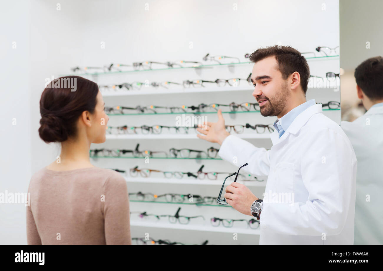 woman and optician showing glasses at optics store Stock Photo - Alamy