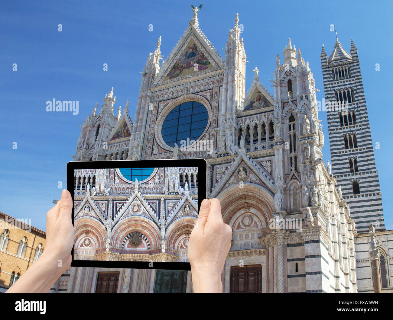 In the bottom left of the photo are hands holding tablet, whose screen ...