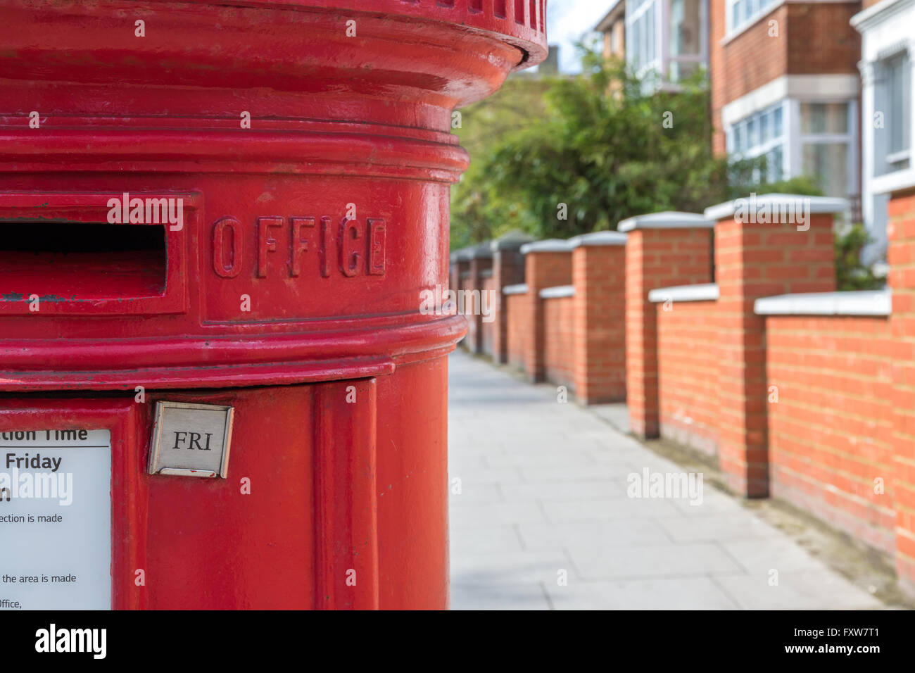 Traditional British post box against blurry terrace house background ...
