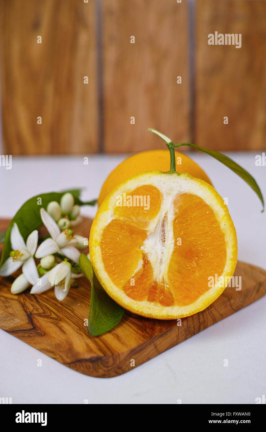 Fresh oranges with leaves and orange tree flowers on olive wooden ...