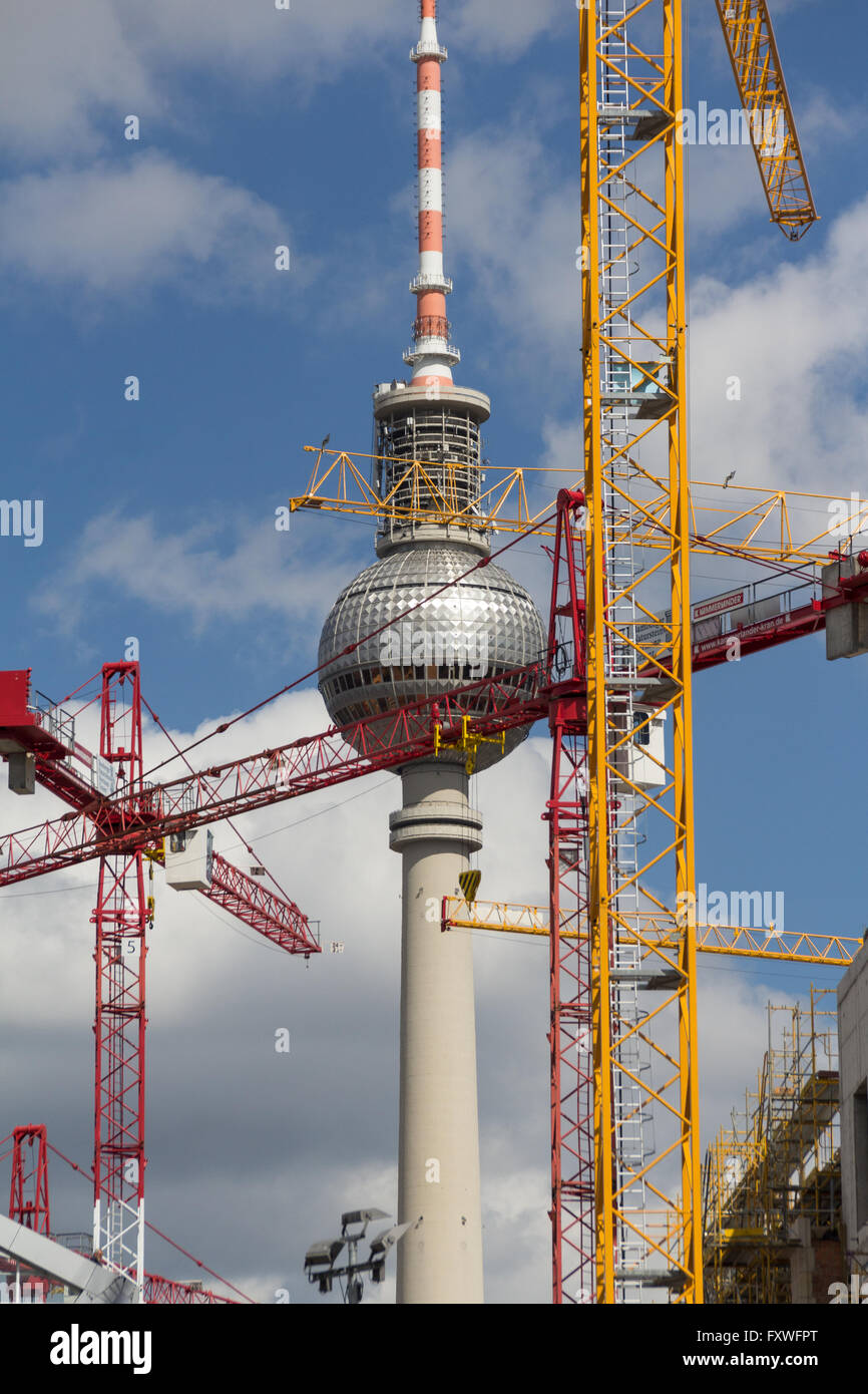The Television tower in berlin behind construction cranes. The Tv tower ...
