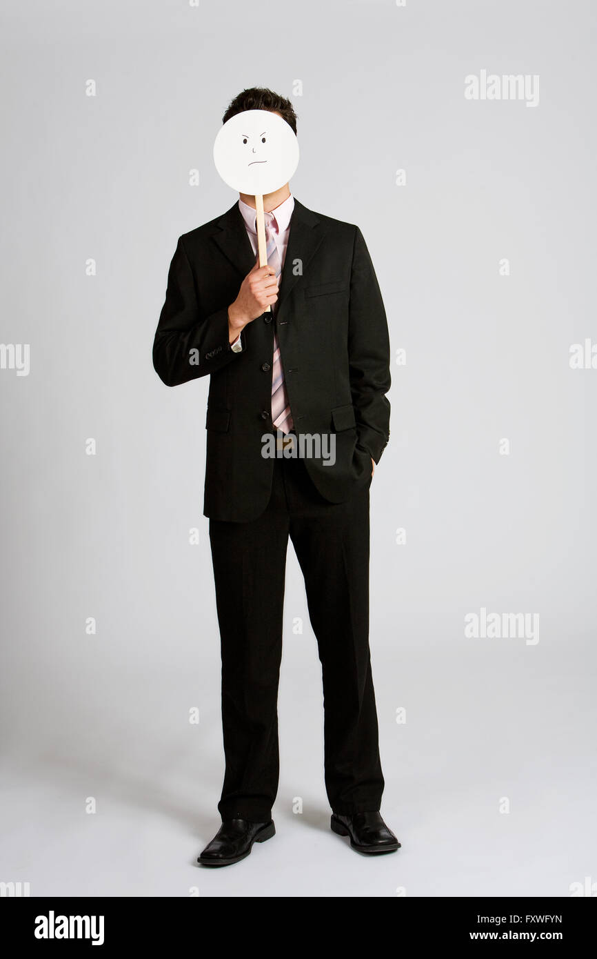 Businessman hiding behind a series of masks Stock Photo - Alamy
