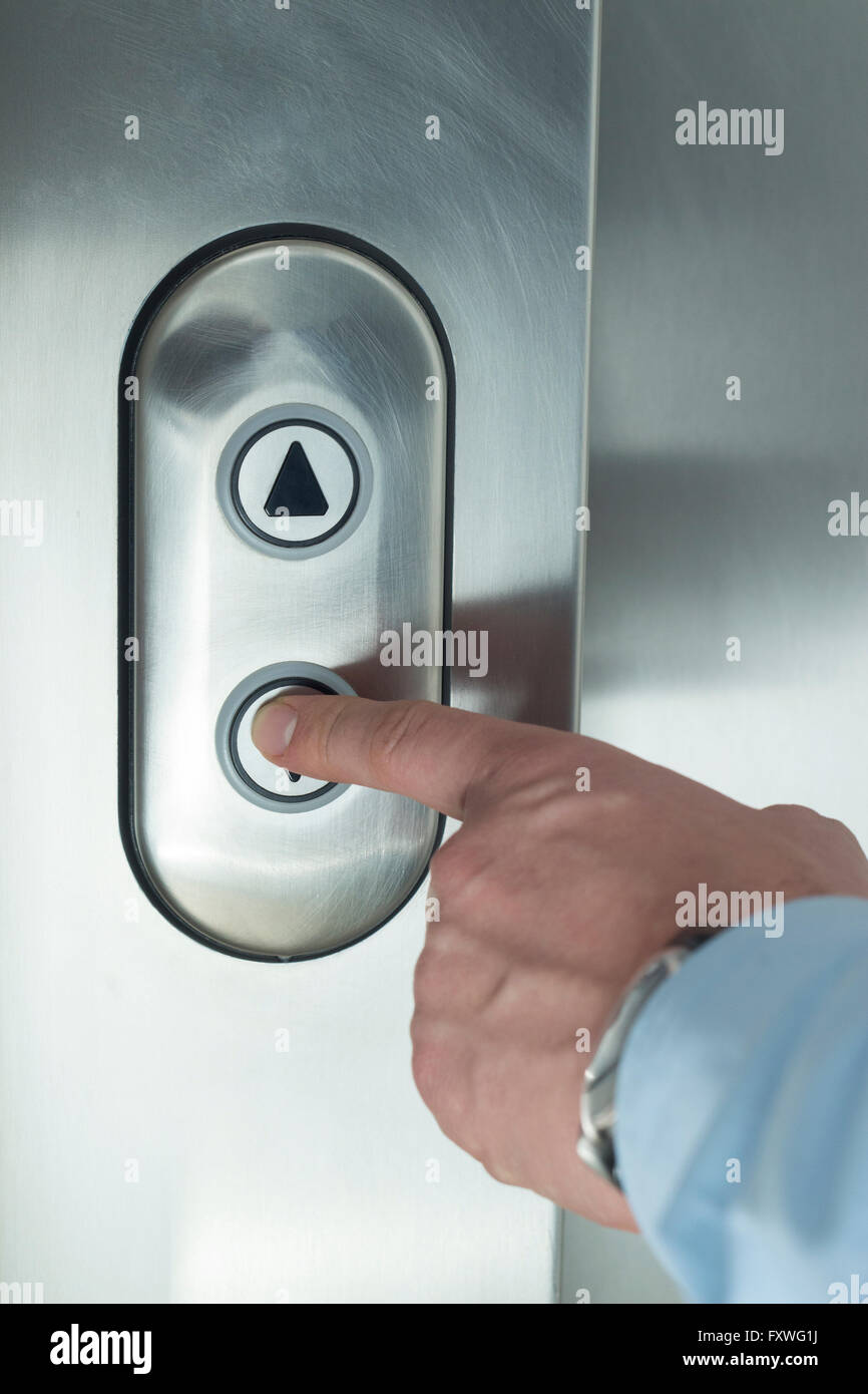 Pushing elevator down button Stock Photo - Alamy