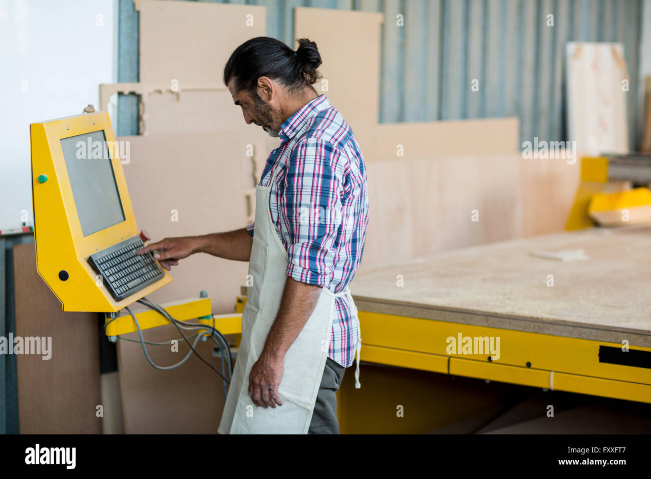 Carpenter pressing controls of engraving machine Stock Photo - Alamy