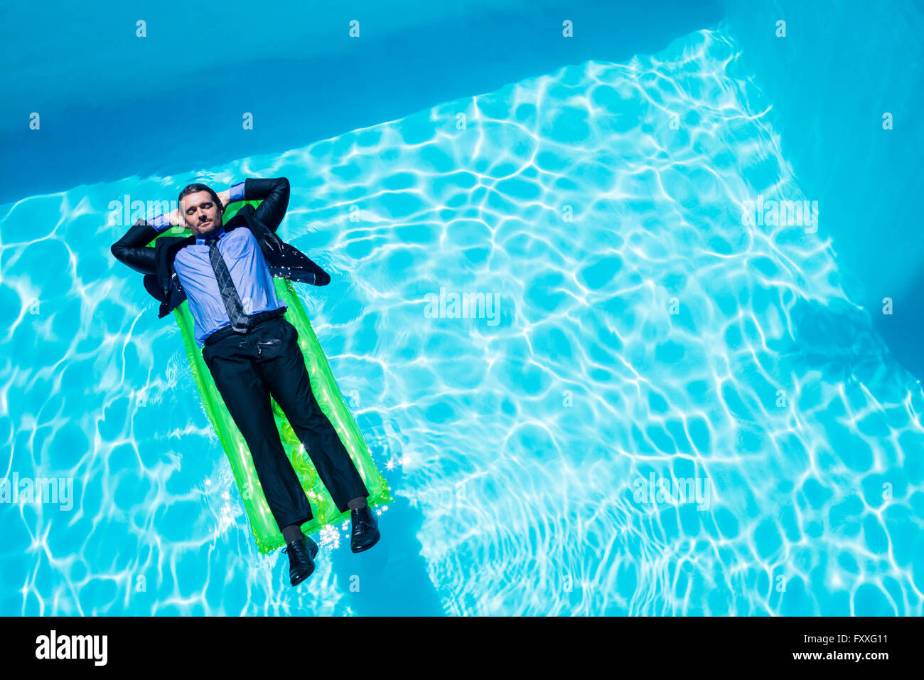 Businessman relaxing on inflatable Stock Photo - Alamy