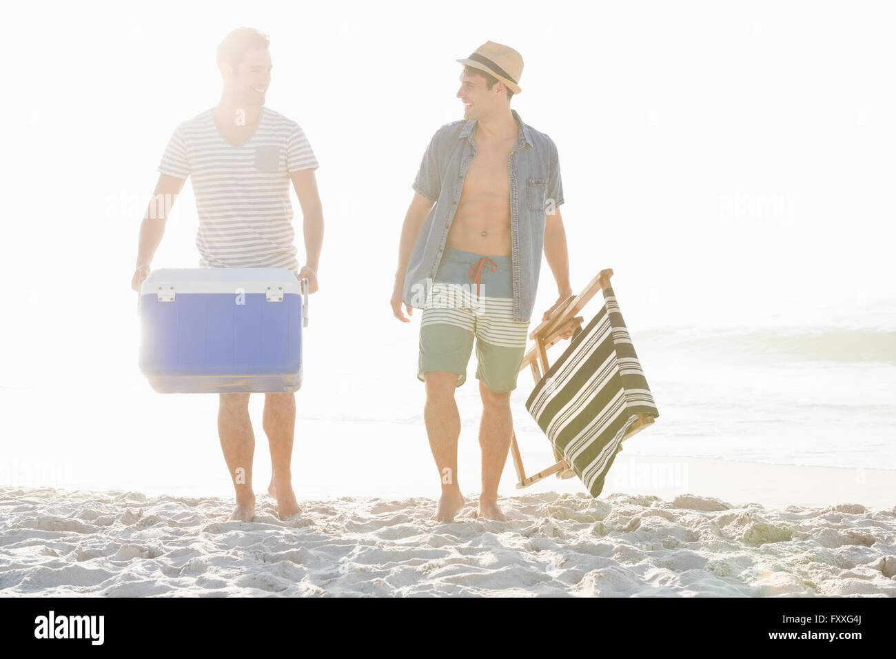 Handsome friends holding cooler Stock Photo - Alamy