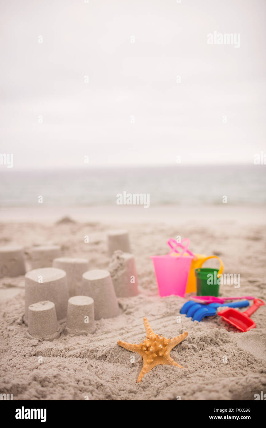 Sandcastle with bucket and spade at beach Stock Photo - Alamy