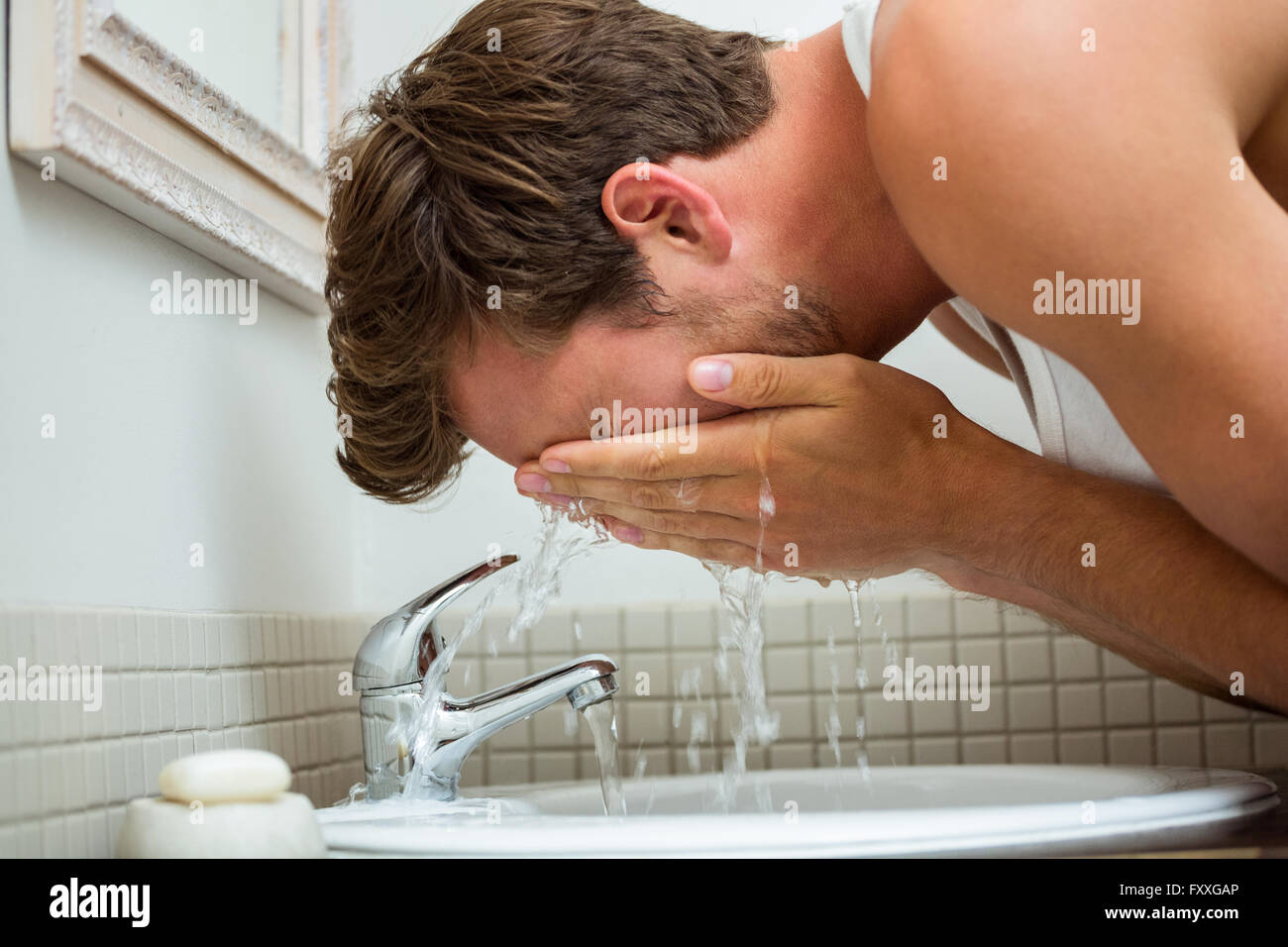 Man washing his face in the bathroom Stock Photo - Alamy