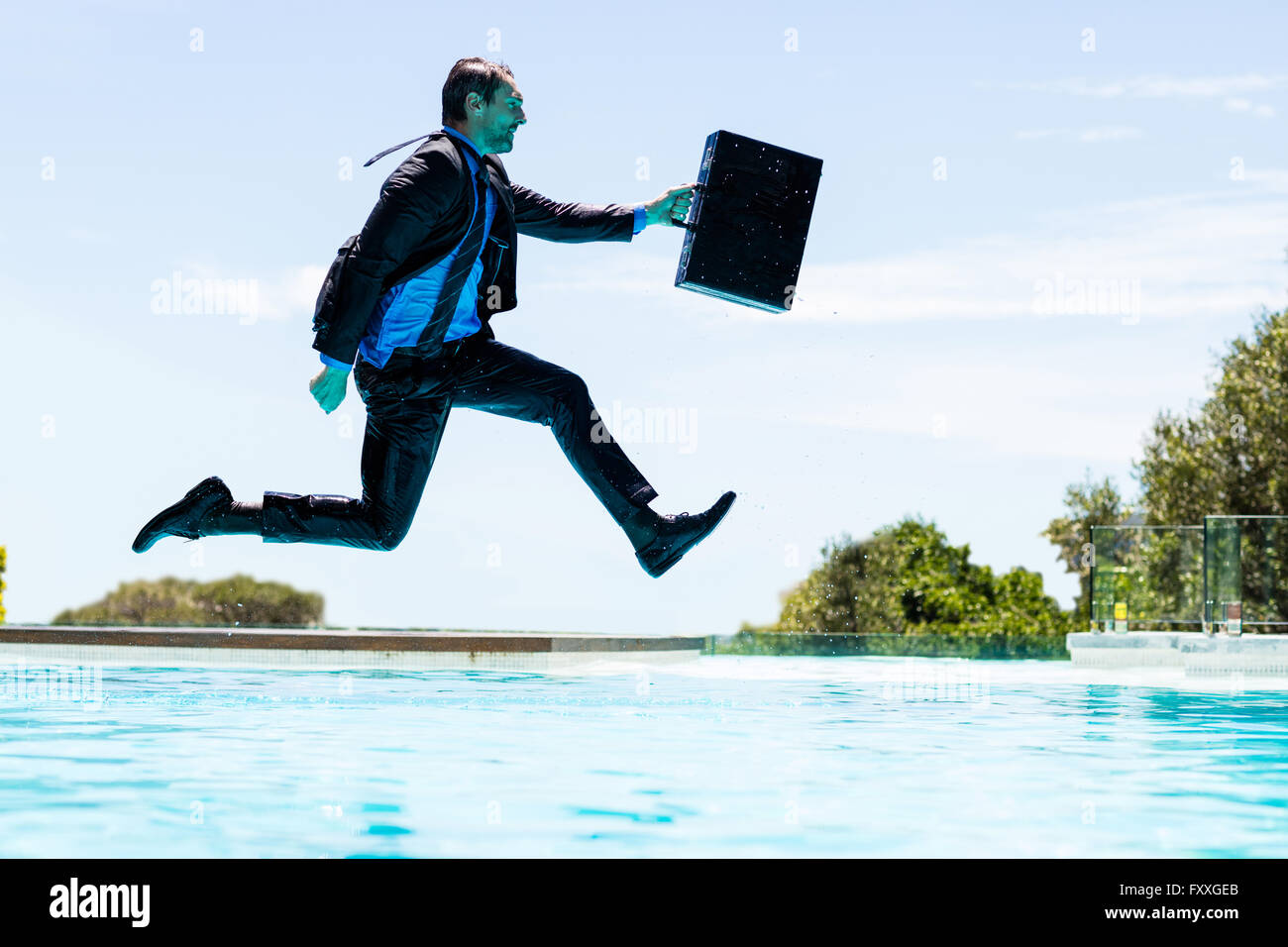Businessman jumping in the swimming pool Stock Photo - Alamy