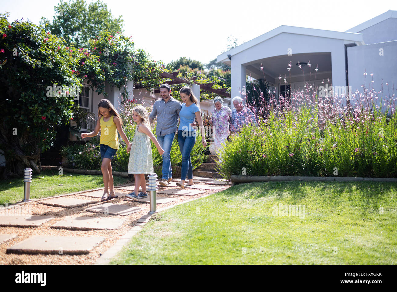 Multi-generation family walking on the garden path Stock Photo - Alamy