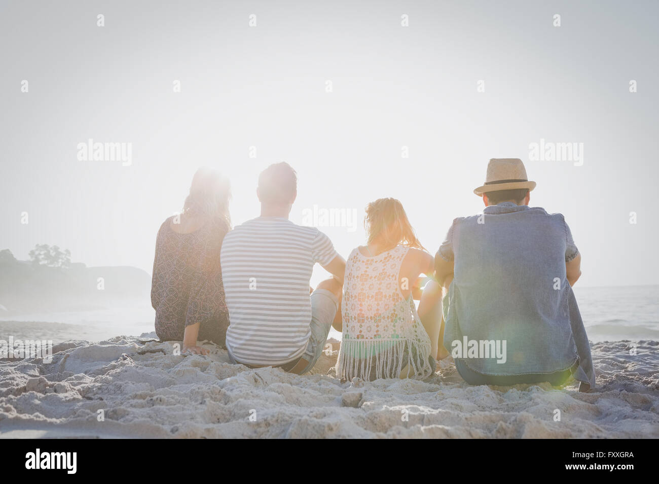 Cute group of friends sitting on the sand Stock Photo - Alamy