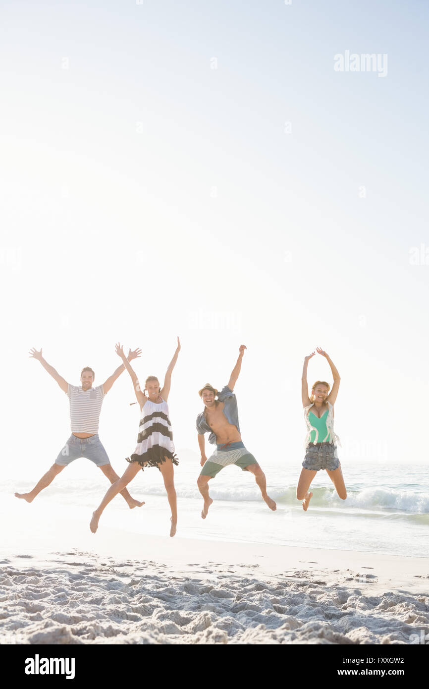 Happy friends jumping on the beach Stock Photo - Alamy