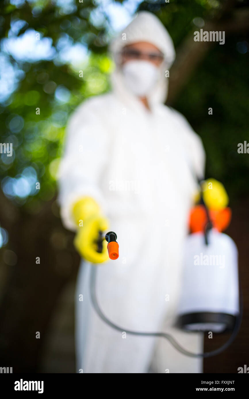 Man wearing protective workwear while spraying insecticide Stock Photo ...