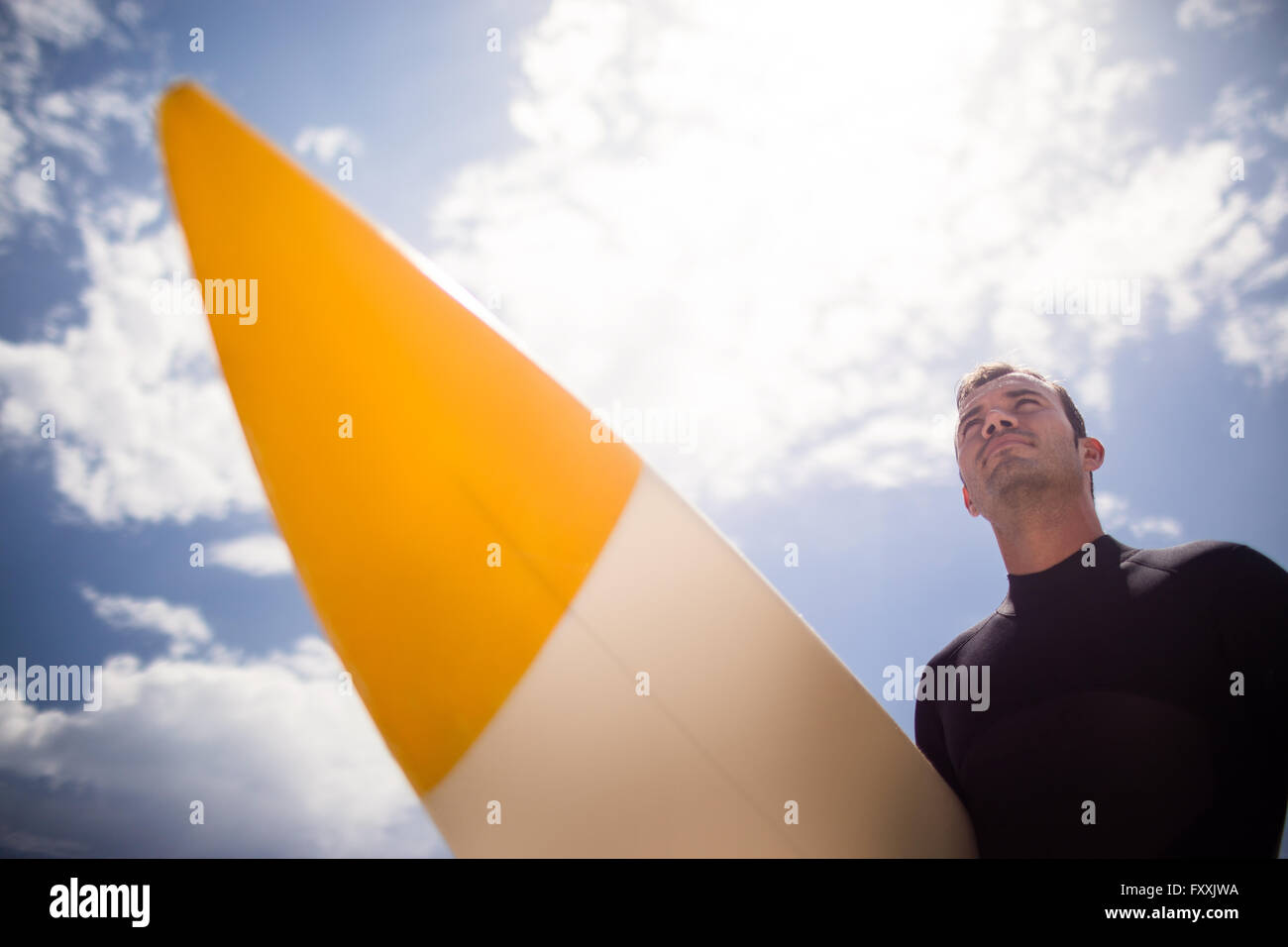Surfer holding surfboard on beach Stock Photo - Alamy