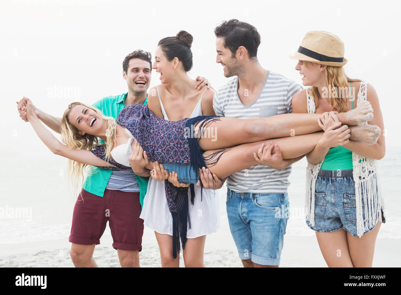 Group of friends holding one of their friend Stock Photo - Alamy