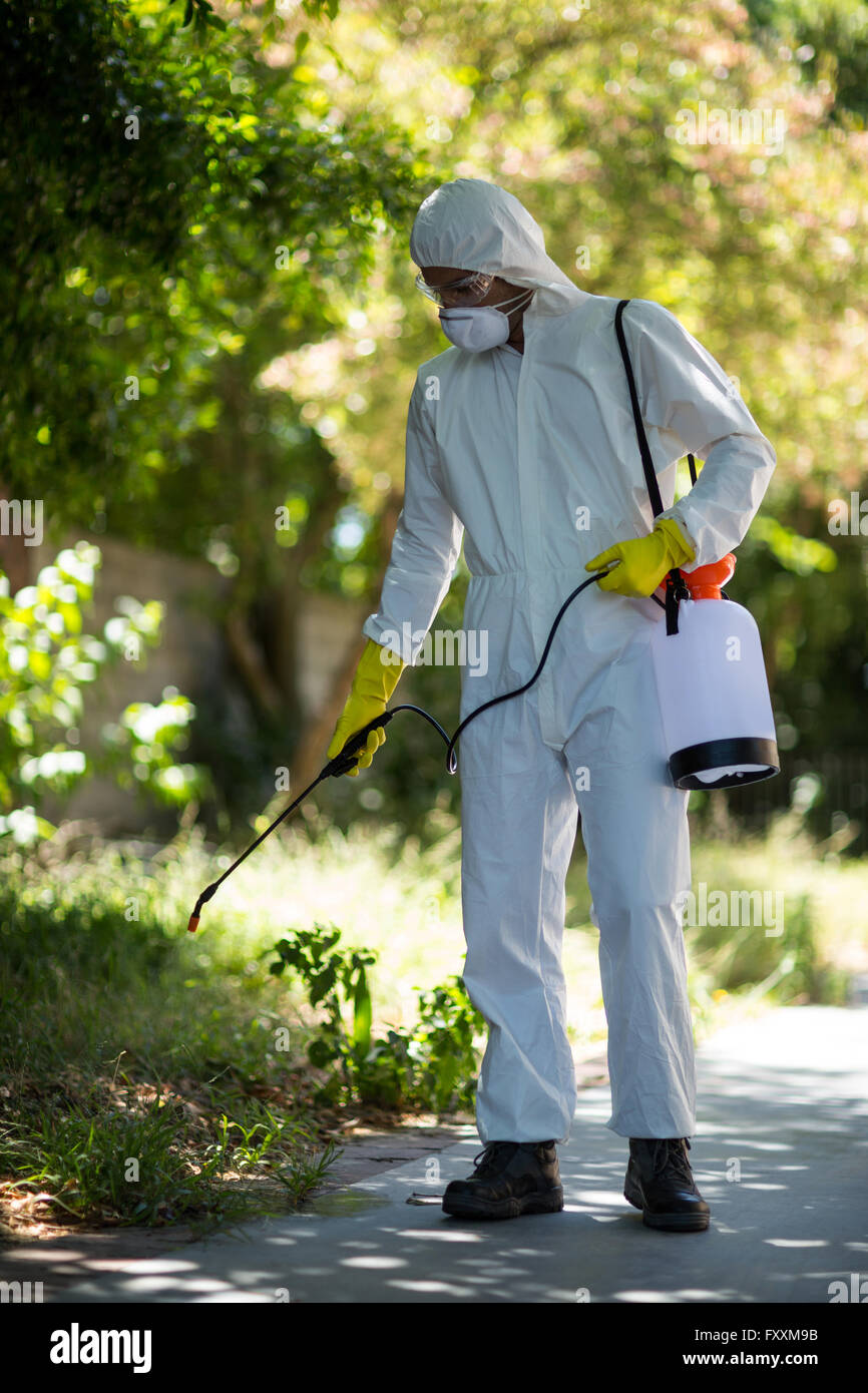 Full length of man spraying insecticide on plants Stock Photo - Alamy