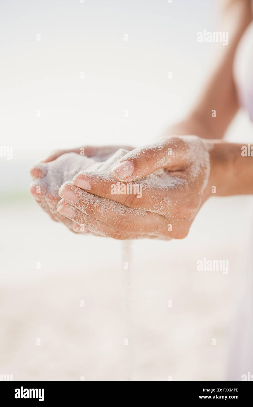 Woman holding sand on the beach Stock Photo - Alamy