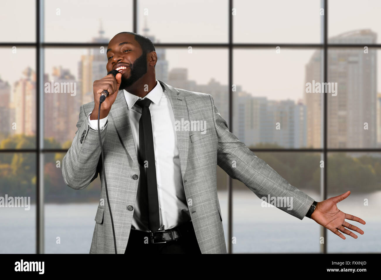 Black guy sings into microphone Stock Photo - Alamy