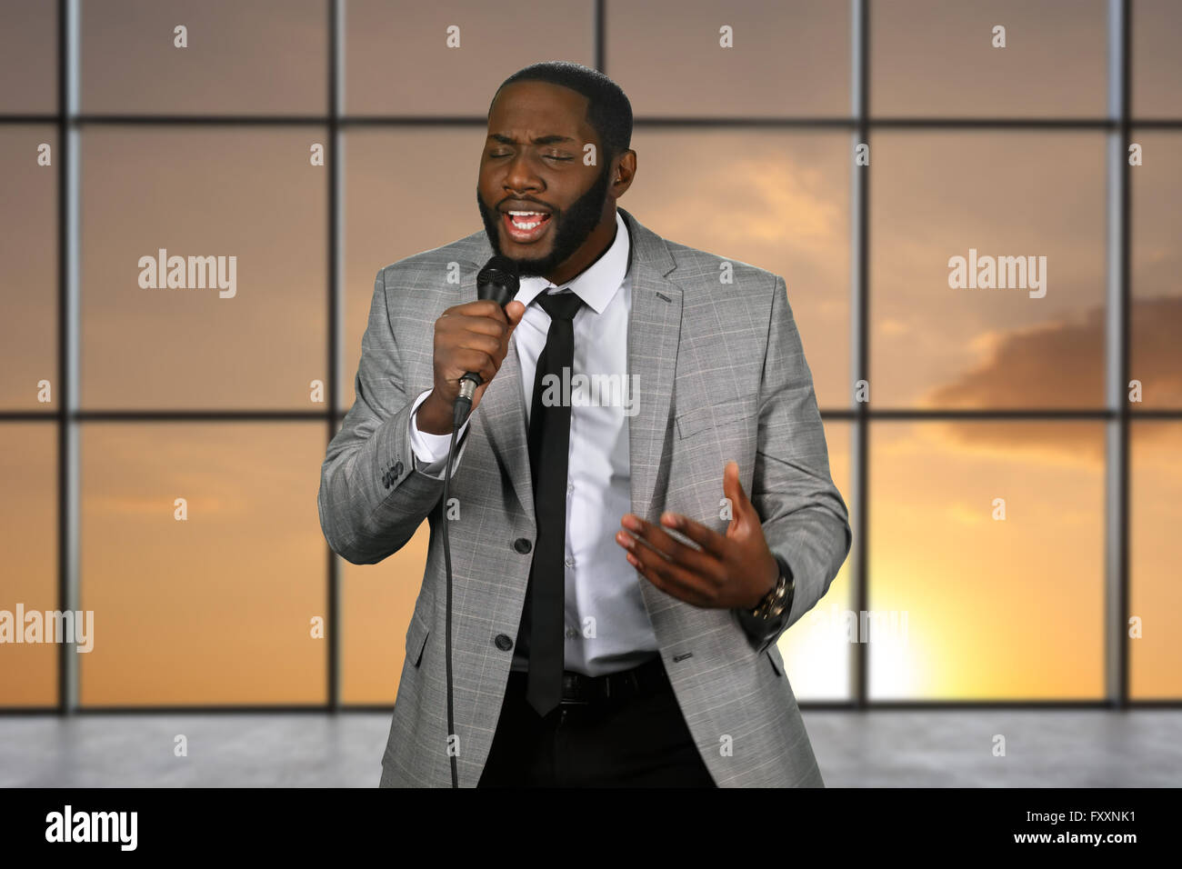 Black singer holding microphone Stock Photo - Alamy