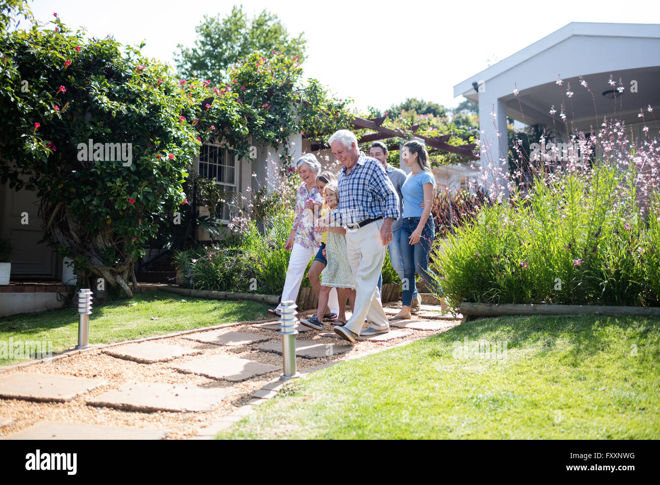 Multi-generation family walking on the garden path Stock Photo - Alamy