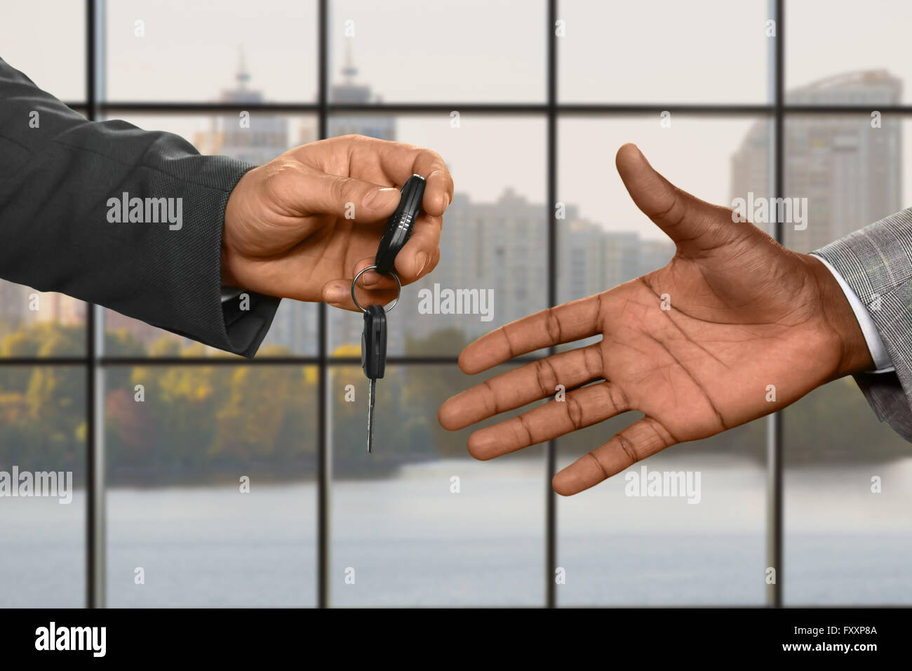 Caucasian businessman's hand giving key Stock Photo - Alamy