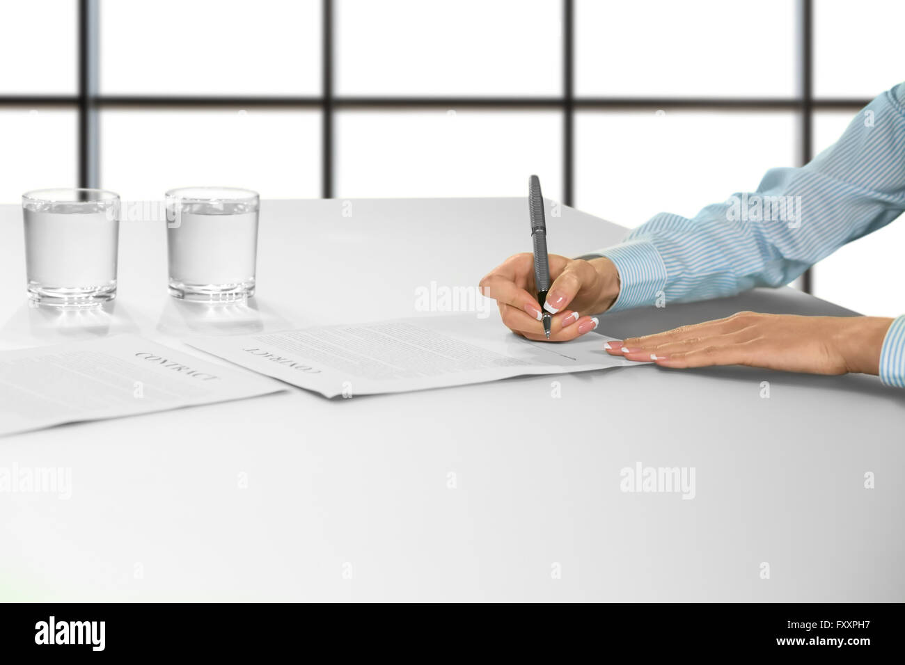 Businesswoman's hand signing document Stock Photo - Alamy