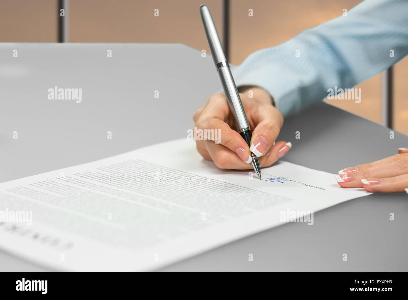 Young lady's hand signing document Stock Photo - Alamy