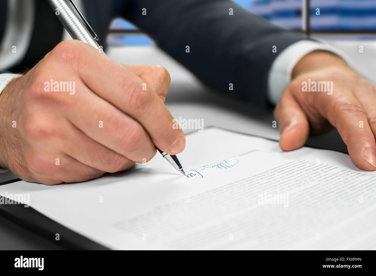 Mature businessman's hand signing document Stock Photo - Alamy