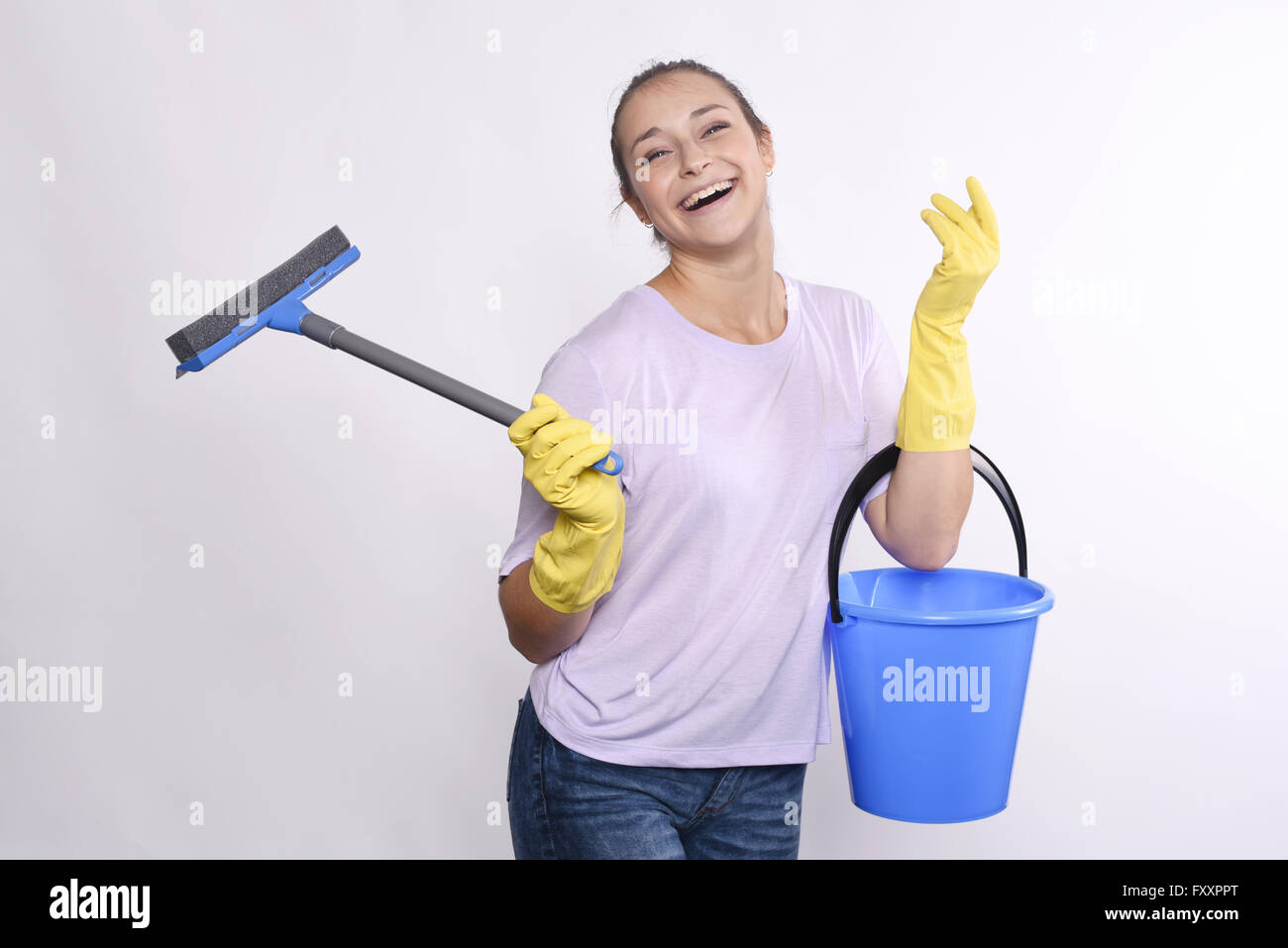 Portrait of young woman holding cleaning products. Isolated on white ...