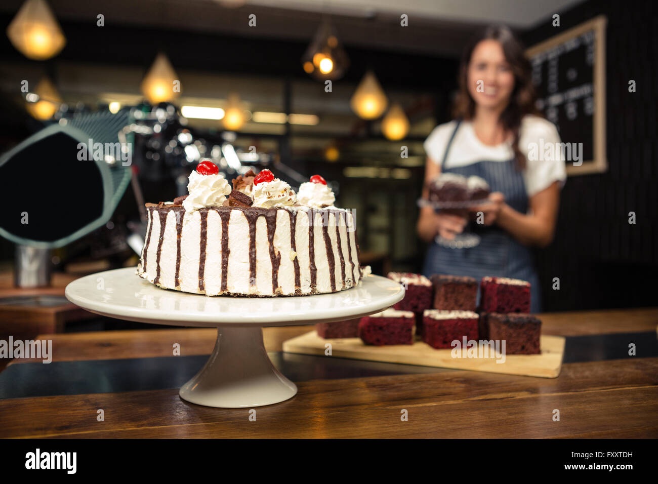 Smiling barista holding plate with cake Stock Photo - Alamy
