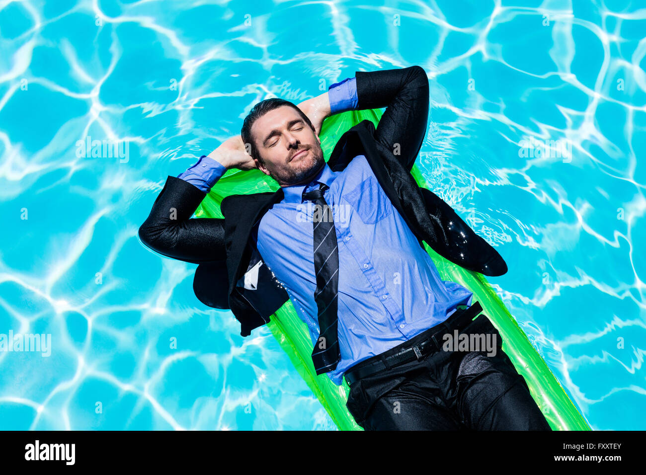 Businessman relaxing on inflatable Stock Photo - Alamy