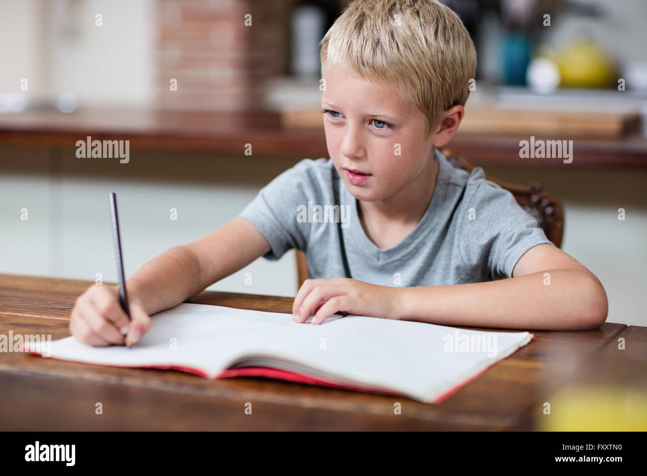 Boy doing homework in kitchen Stock Photo - Alamy