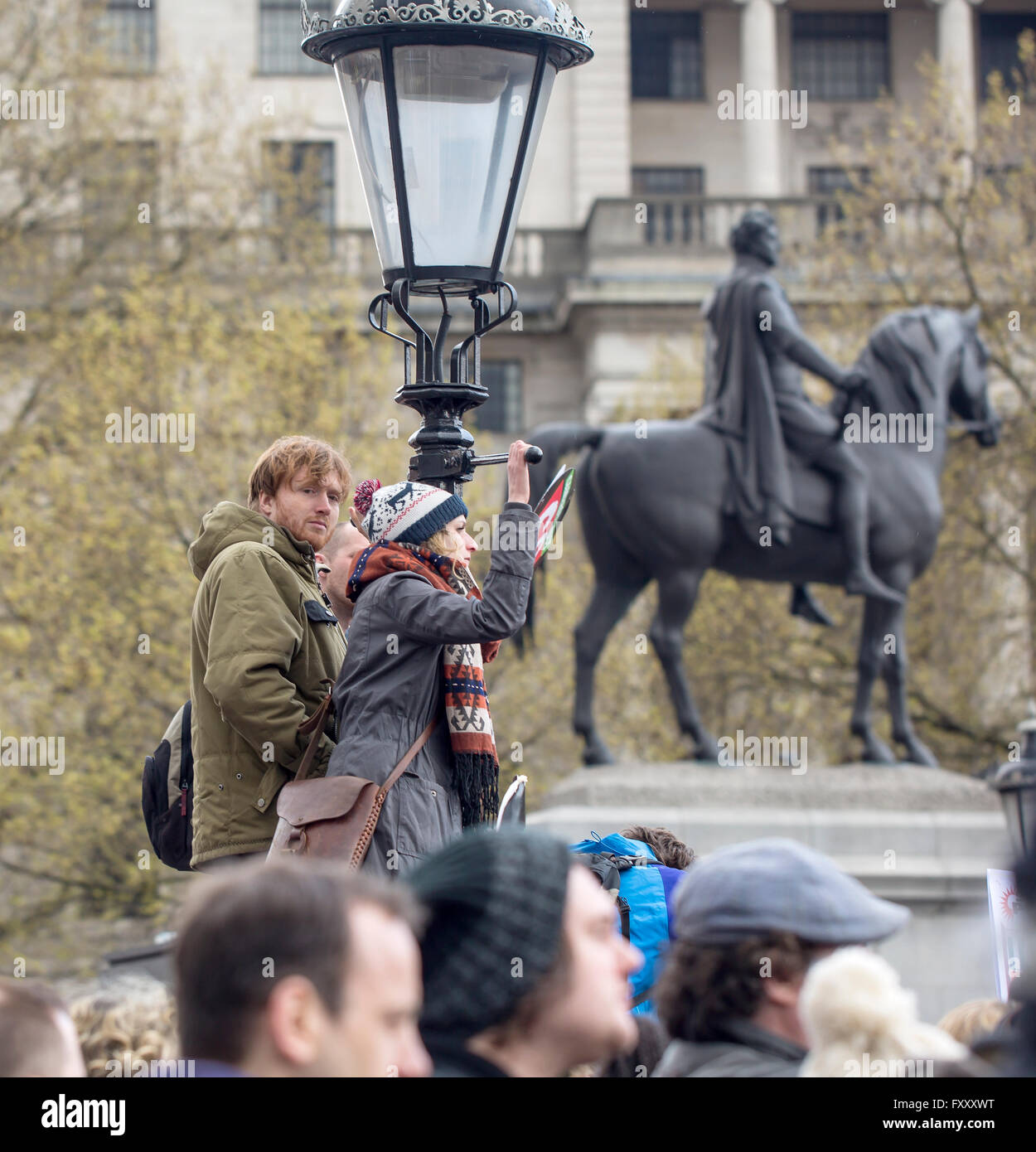 Watching from a high vantage point, three young people listen to the ...
