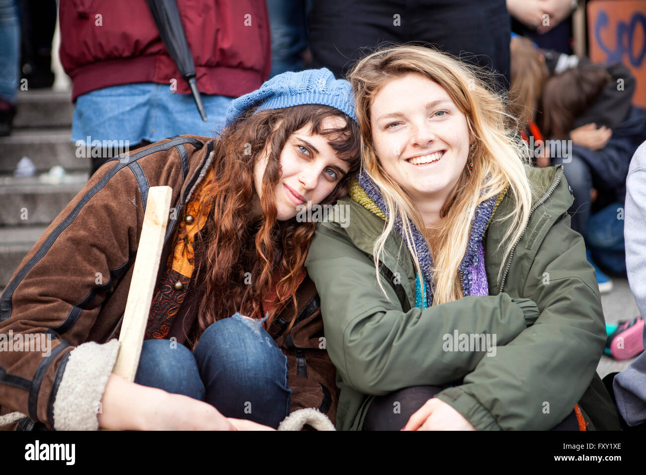 Two friends sit and listen to the speeches at the rally after the anti ...
