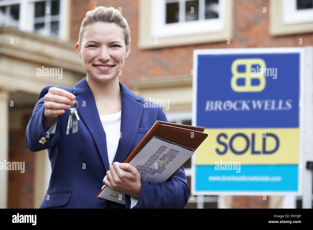 Female realtor holding sold sign hi-res stock photography and images ...