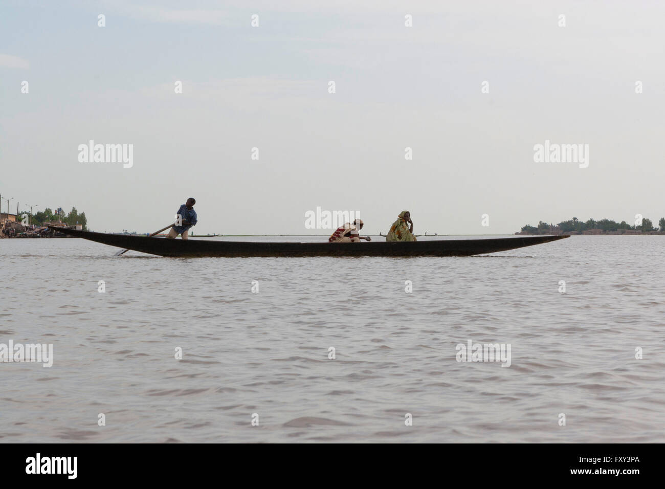 Man rowing a pirogue carrying two women on River Niger, Mali Stock ...