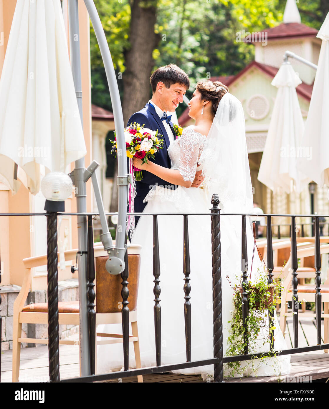 wedding couple hugging, the bride holding a bouquet of flowers, groom ...