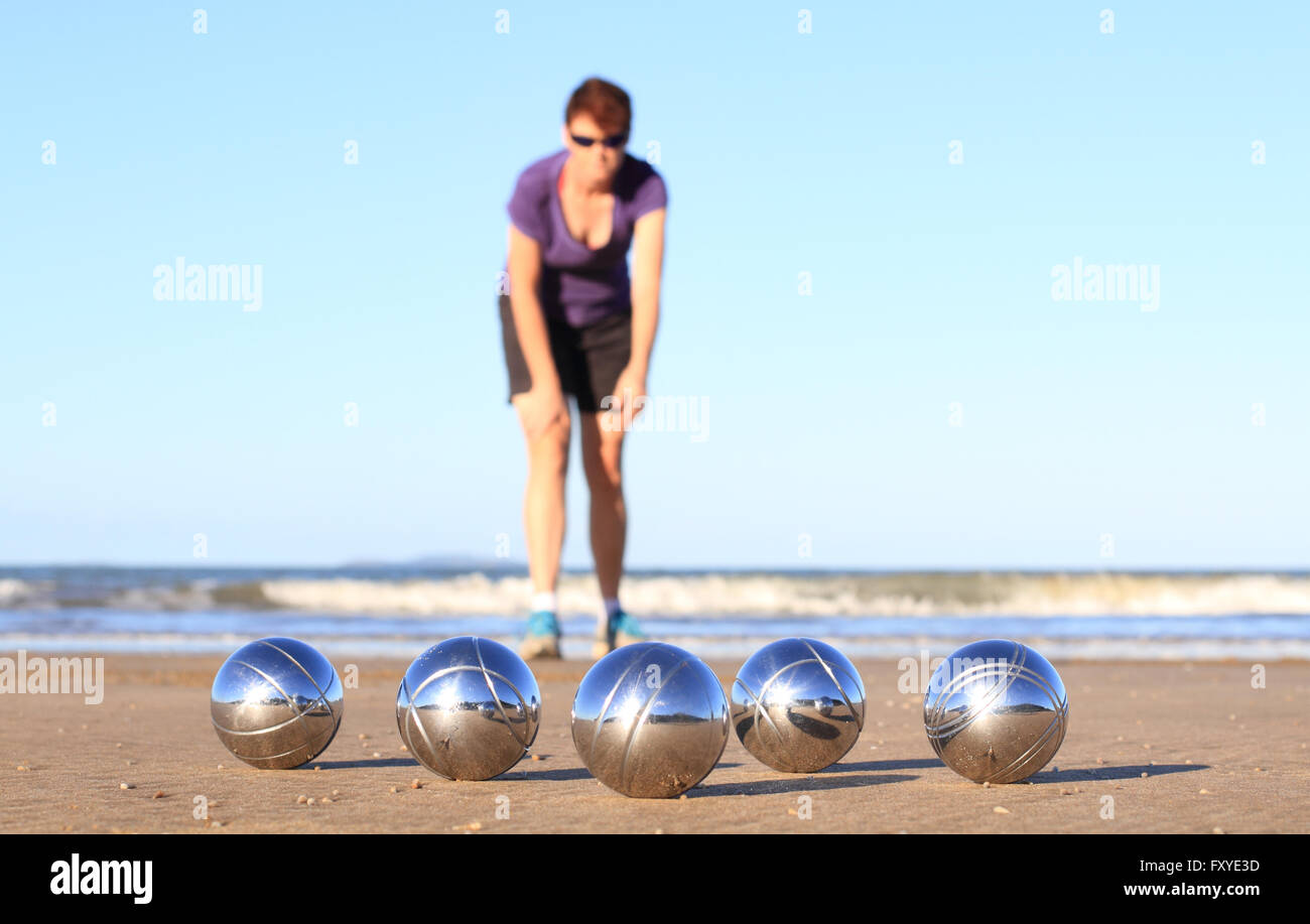 A woman playing boules on a beach Stock Photo - Alamy