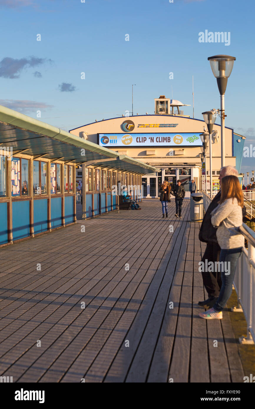 Visitors enjoy a stroll in the evening light at Bournemouth pier in ...