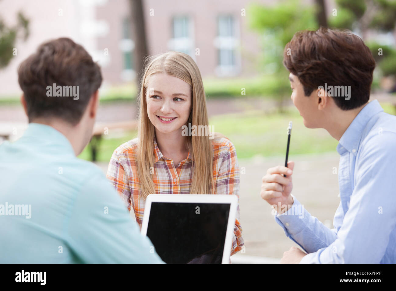 Domestic students and international students in college seated around a ...