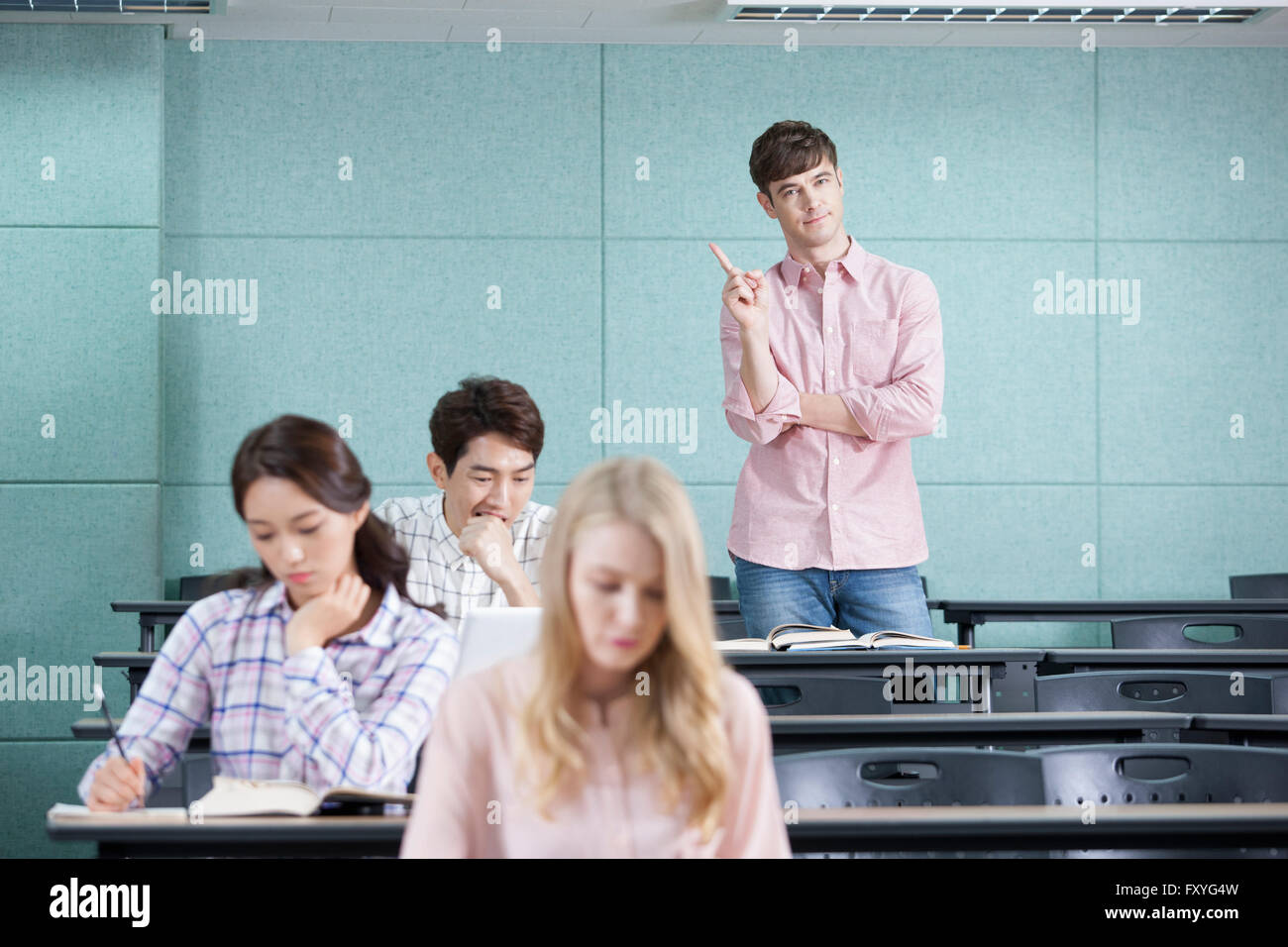 International student standing in a classroom in college with his ...